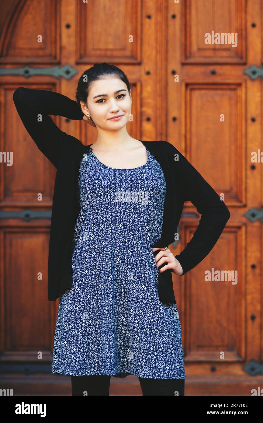 Outdoor fashion portrait of young 20 year old girl wearing blue dress ...