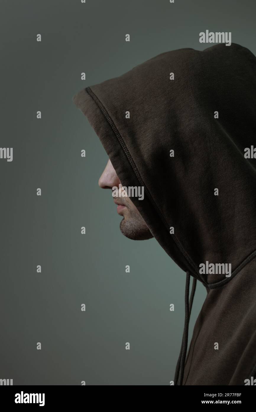 dark large portrait of a guy in a hood with stubble in profile Stock ...