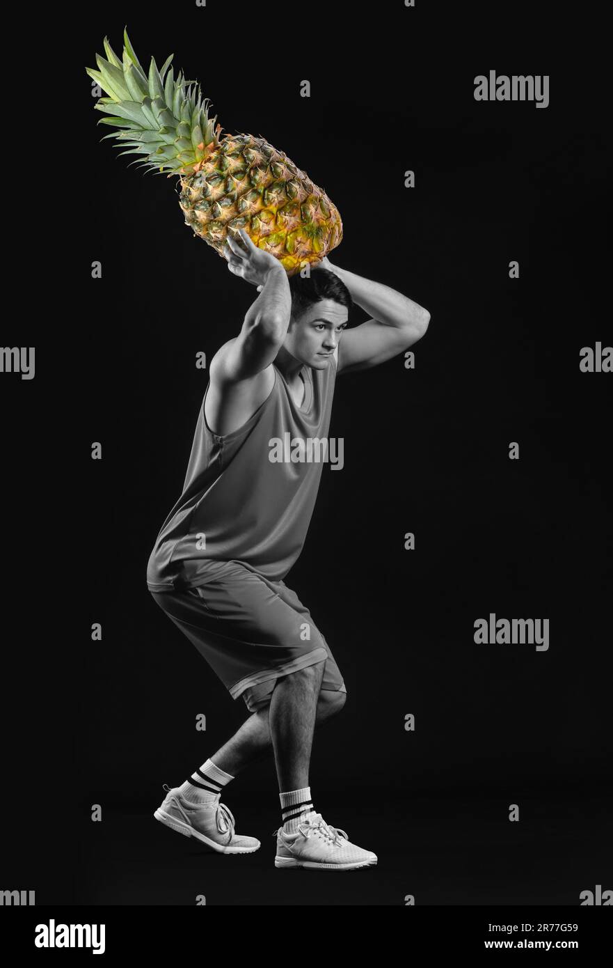 Male basketball player with fresh pineapple on dark background Stock ...