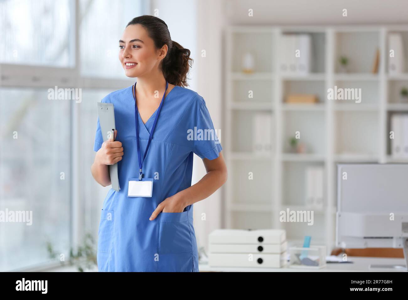 Female medical assistant with clipboard in clinic Stock Photo - Alamy