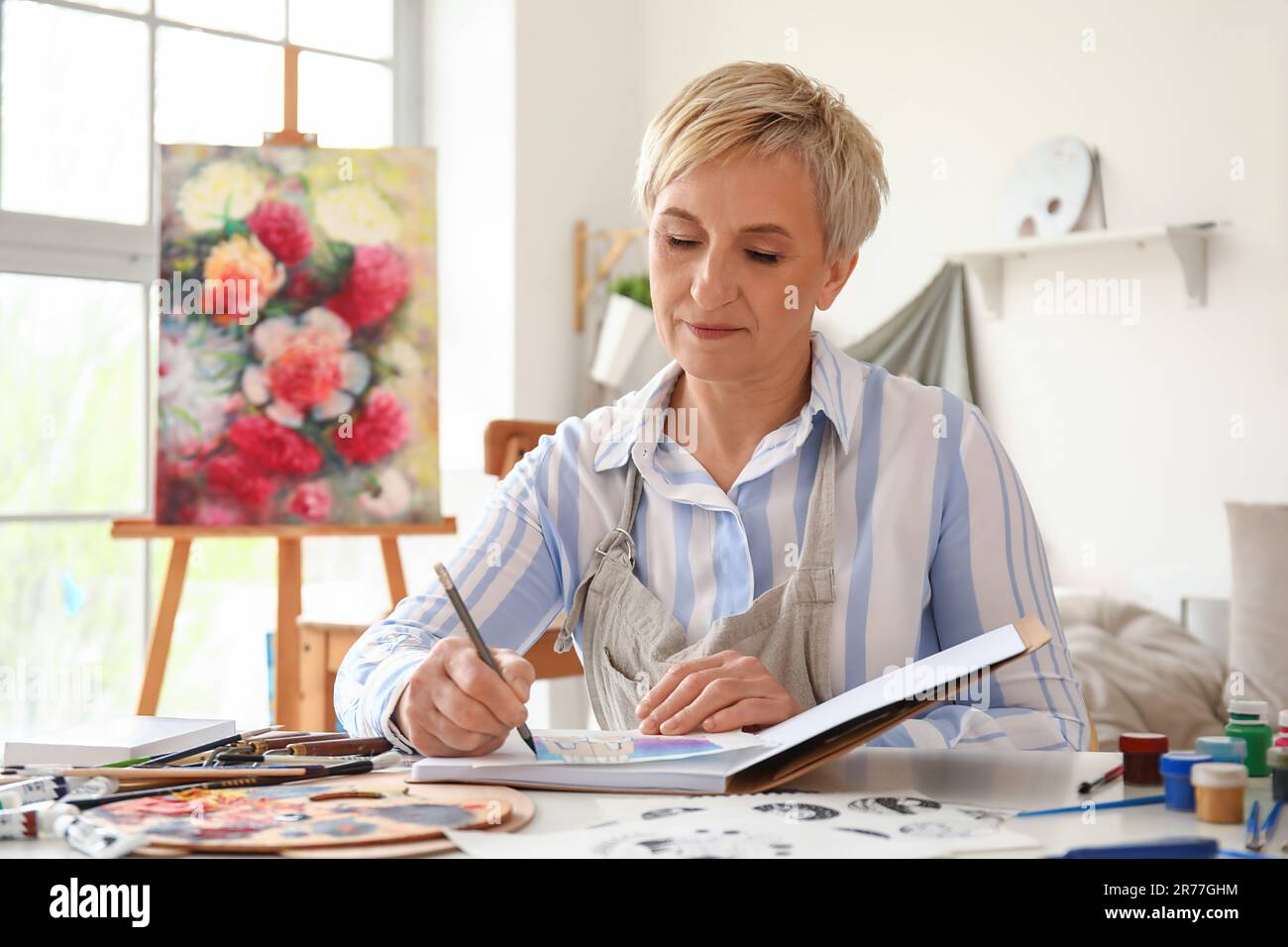 Mature female artist drawing sketch in workshop Stock Photo - Alamy