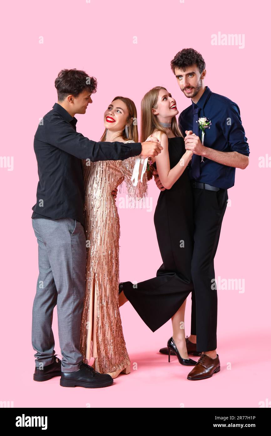 Beautiful prom couples dancing on pink background Stock Photo - Alamy