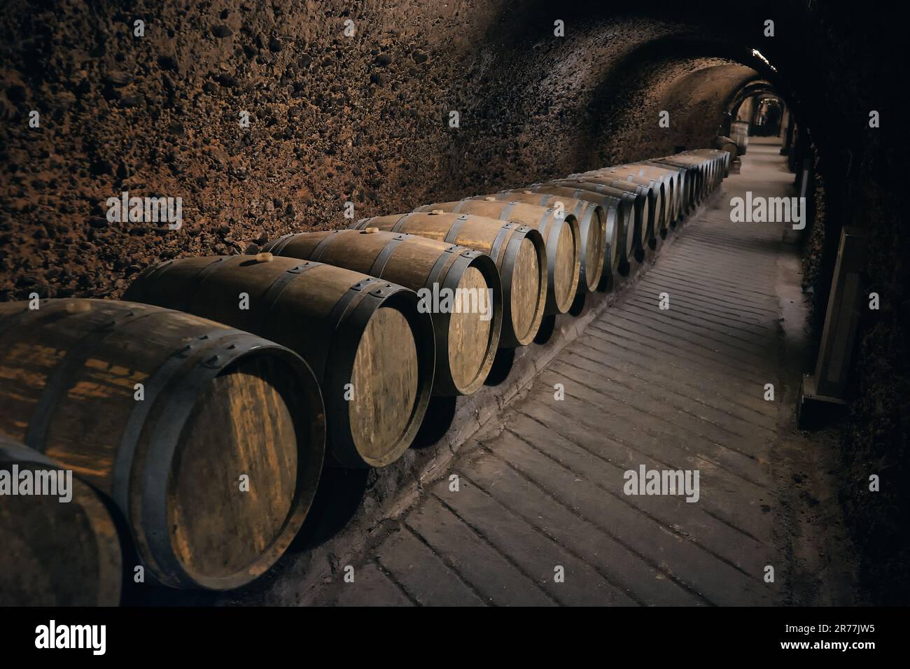 Row of wooden barrels bound with iron hoops in a bodega. Wine barrels ...