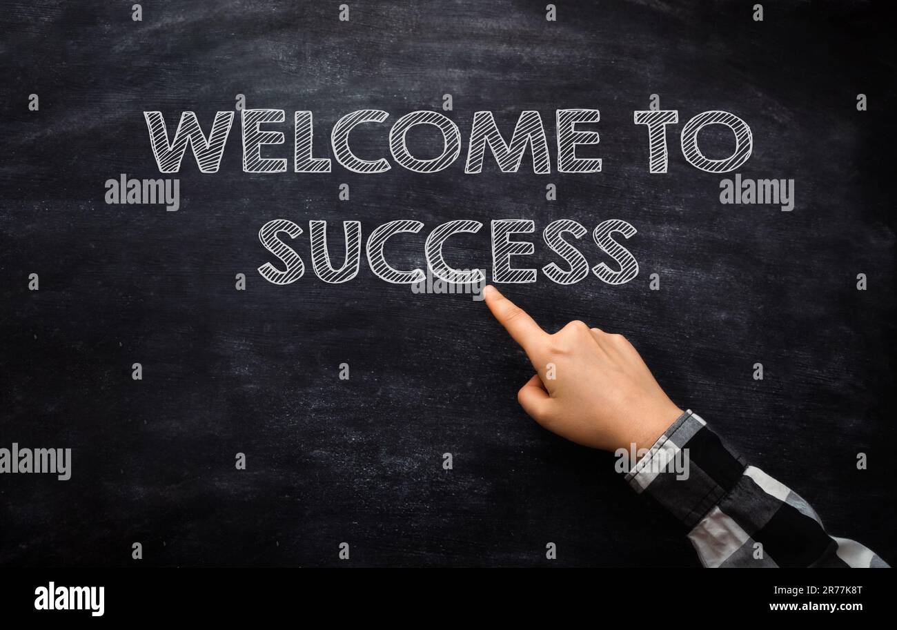 The hand points to the inscription on the board Welcome to Success ...