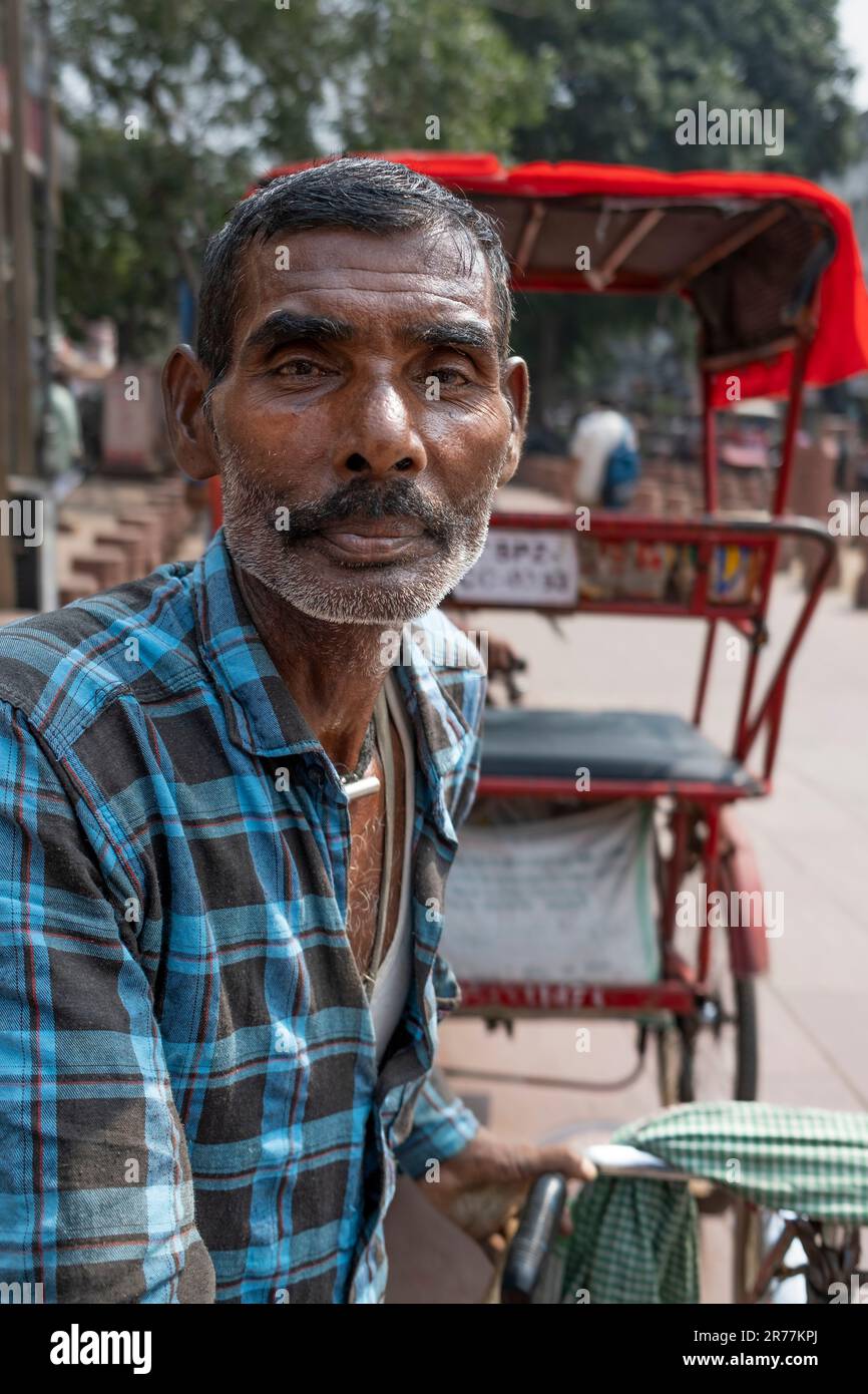 Pedal rickshaw cab driver takes break in busy market, Old Delhi section ...