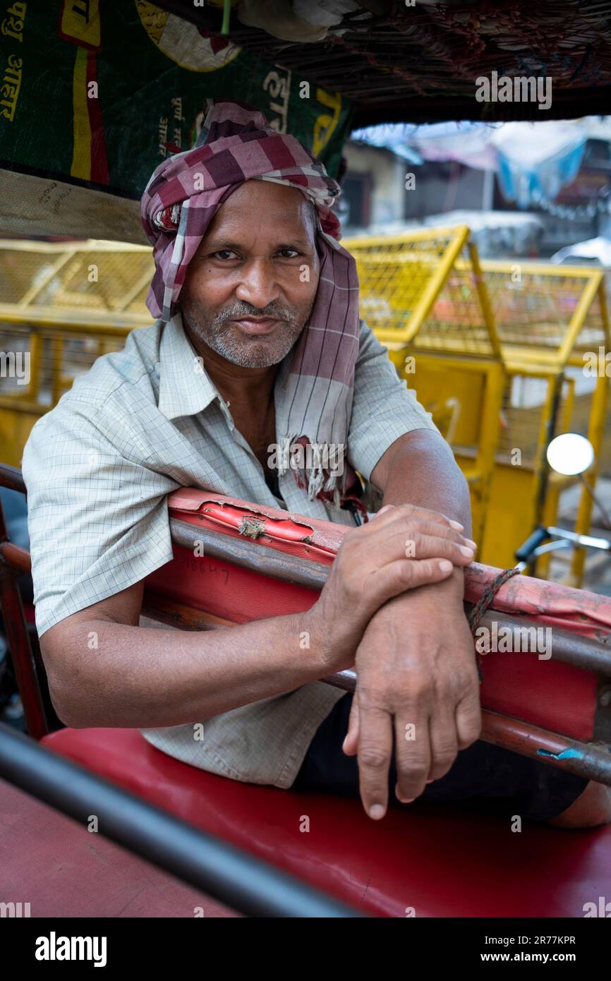 Pedal rickshaw cab driver takes break in busy market, Old Delhi section ...