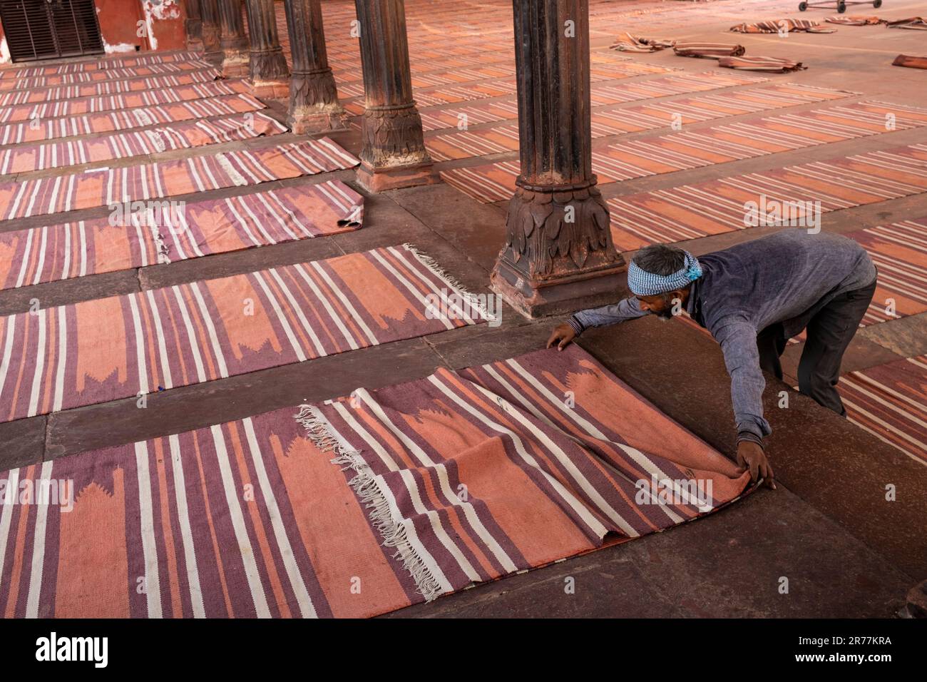 Attendant prepares prayer rugs at Jama Masjid grand mosque, Old Delhi ...