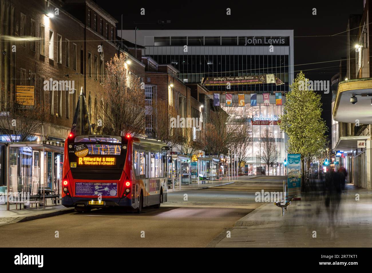 A bus stops outside shops on High Street in the city centre of Exeter ...