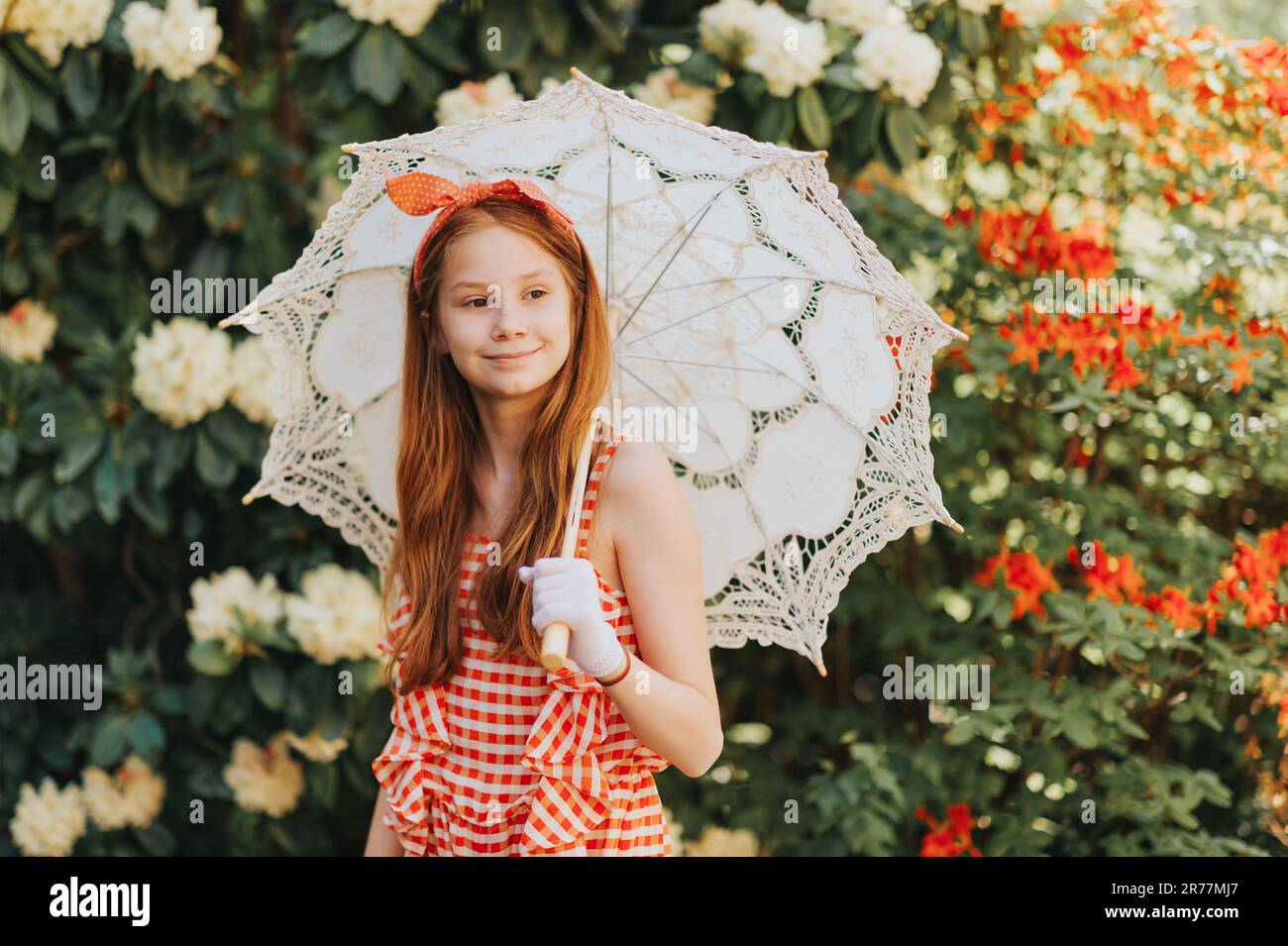 Funny little girl wearing gingham playsuit, white gloves, holding lace ...
