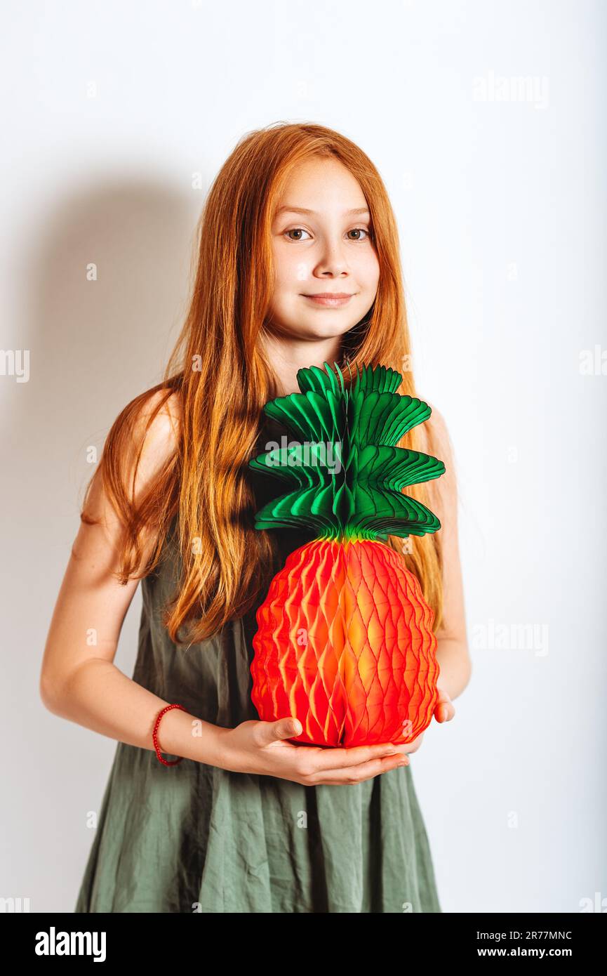 Studio shot of adorable red-haired preteen kid girl, wearing khaki ...