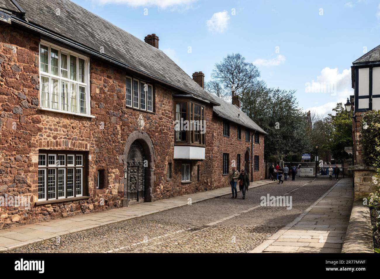 Pedestrians walk past traditional old houses on the cobbled Cathedral ...