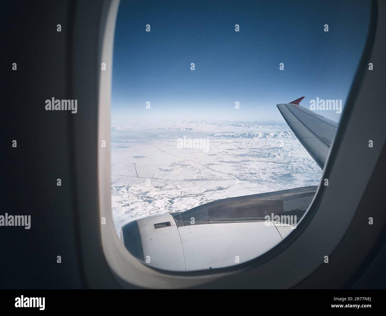 Flying over snow capped mountains. View of snowy landscape under the ...