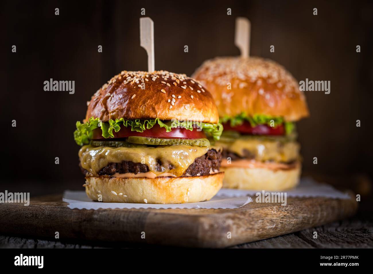 Tasty cheeseburger with lettuce, cheddar cheese, tomato and pickles ...