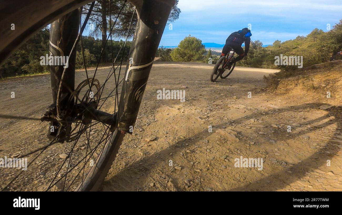 Front wheel point of view on a mountain bike riding on a gravel single ...