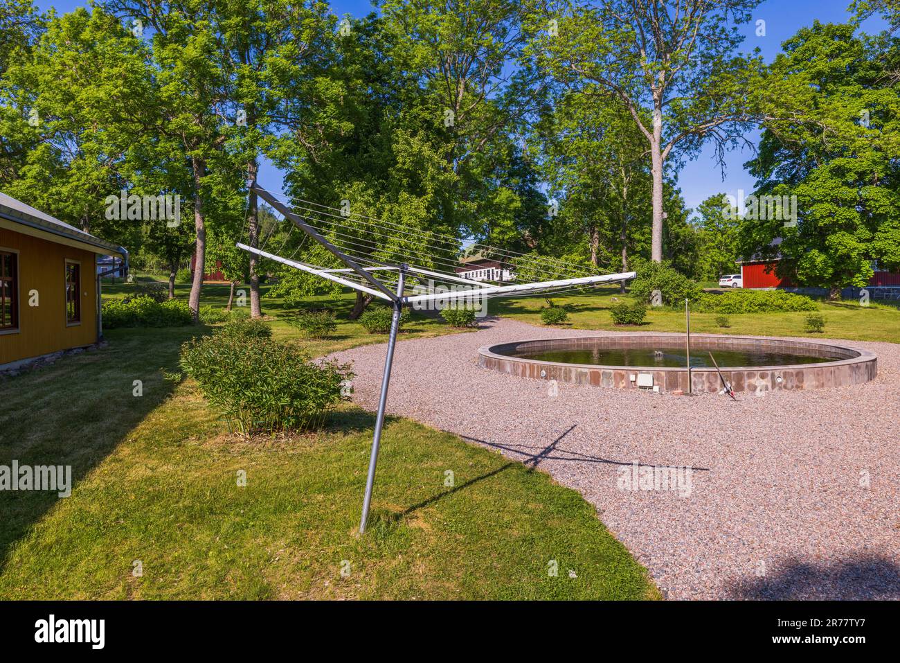 View of metal outdoor clothes dryer on backyard on green trees ...