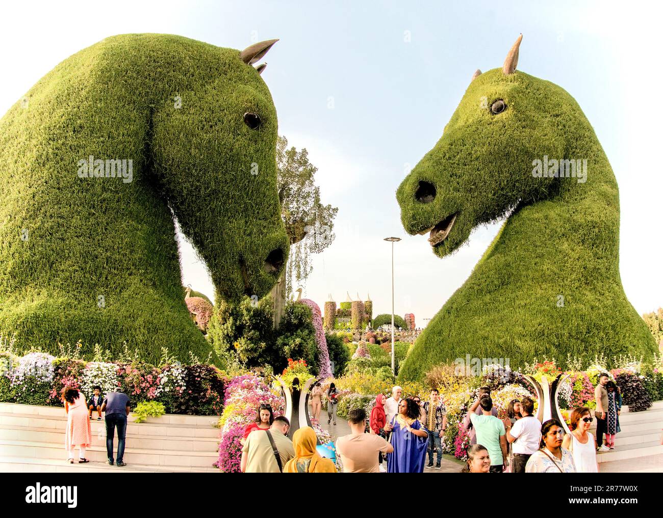 People walk past giant horse heads head bushes in the Miracle Flower ...