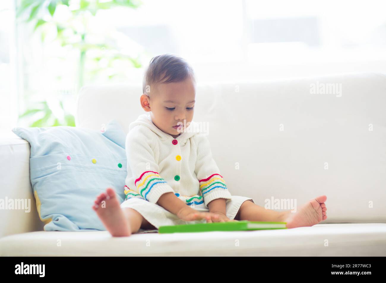 Baby boy reading a book. Kids read. Adorable Asian child holding a fun ...