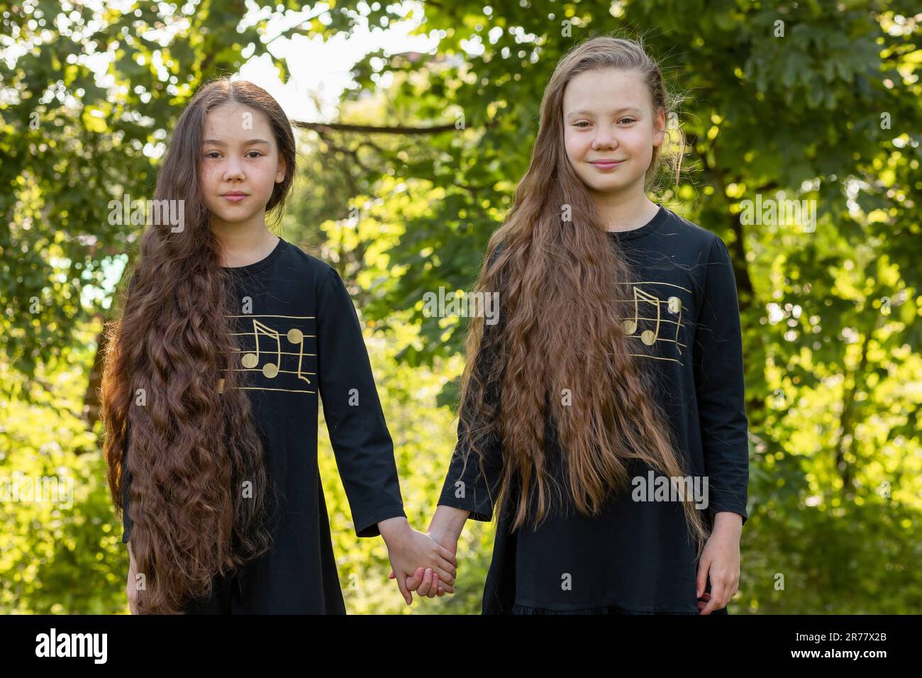 Portrait Smiling Two Sisters With Extra Long Hair Holds Hands In Sunny ...