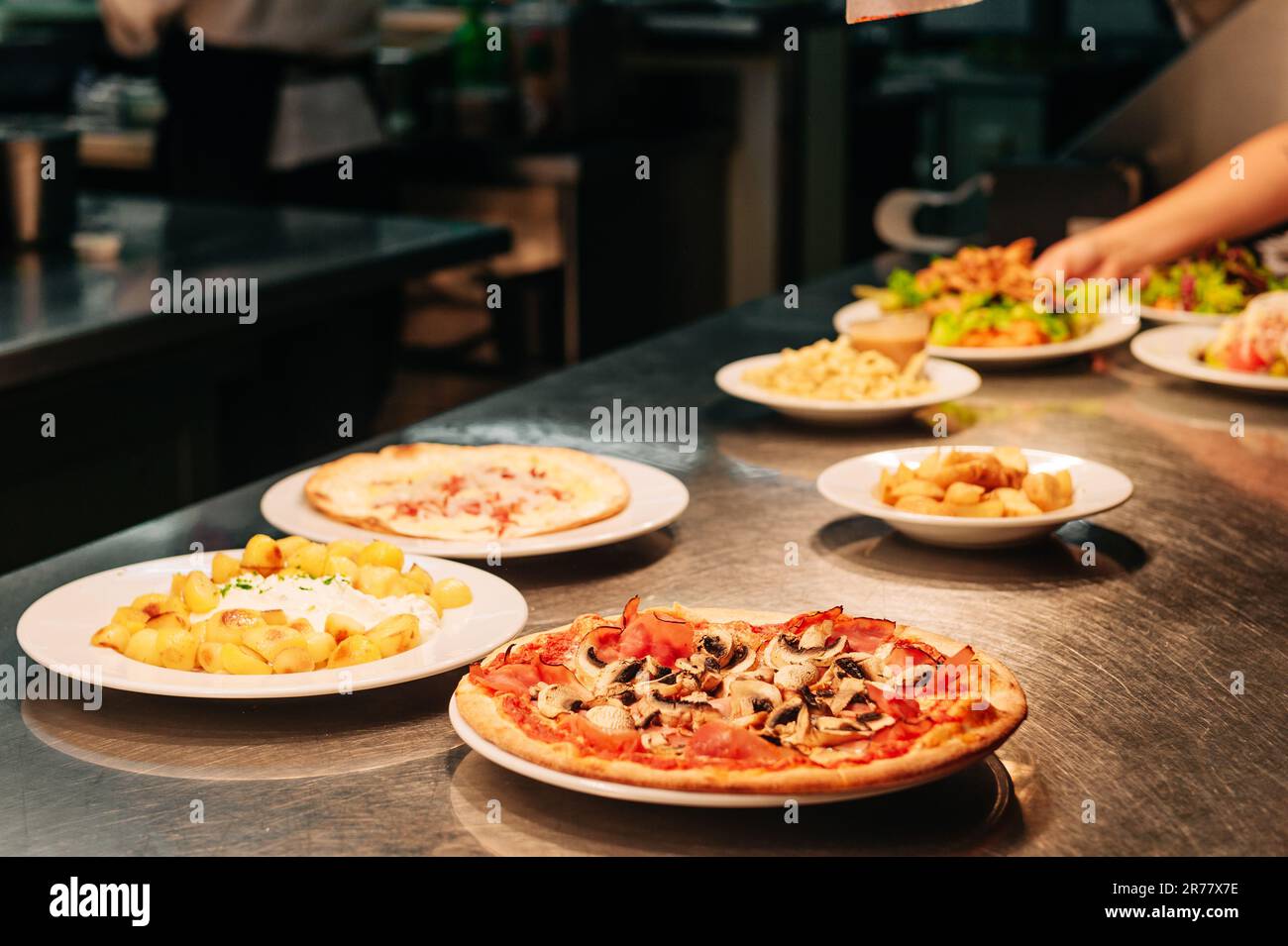 Food orders on the kitchen table in the restaurant, pizza with ham and ...