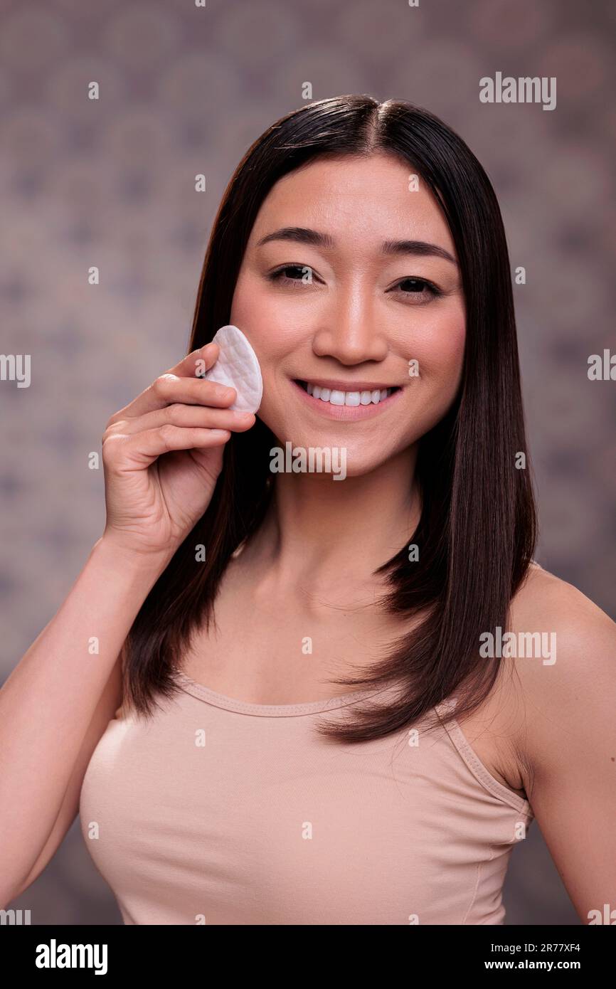 Cosmetology smiling asian model doing skincare routine portrait ...