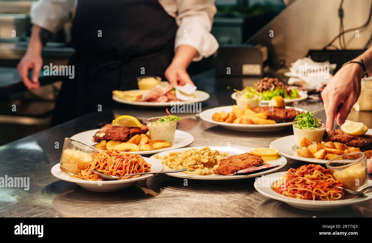 Food orders on the kitchen table in the restaurant, pasta spaghetti ...