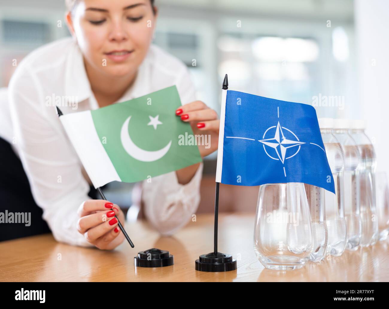 Businesswoman arranging the flags of NATO (OTAN) and Pakistan for ...