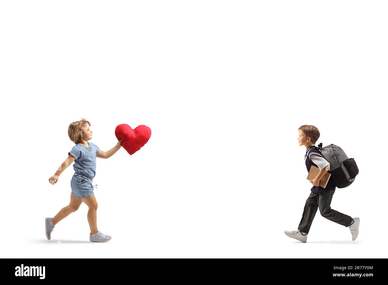 Little girl carrying a red heart and running towards a schoolboy ...