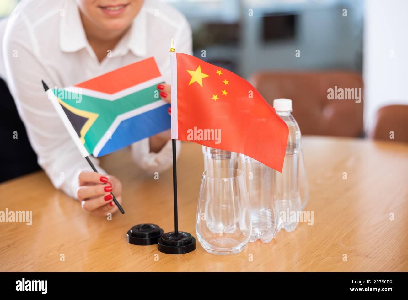 Unrecognizable girl sets midget flags of China and South Africa before ...