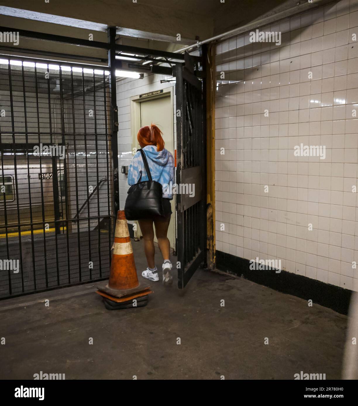 A woman enters the subway in New York via the emergency exit gate ...