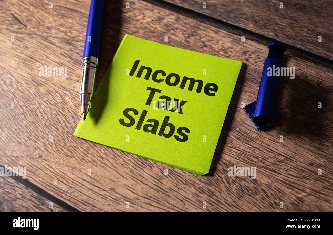 Income Tax Slabs inscription on white card. Workplace background, top ...
