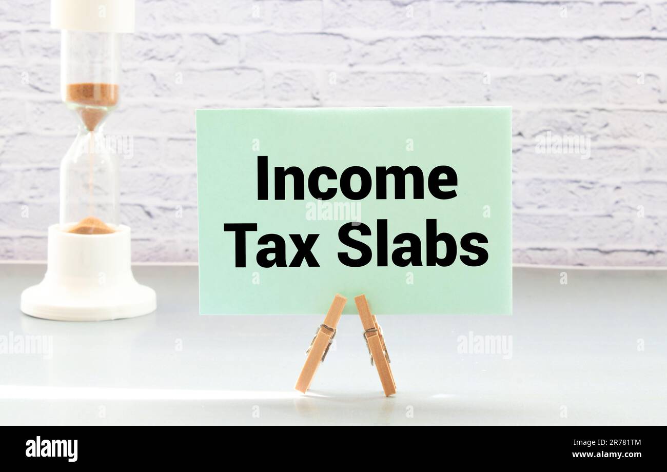 Income Tax Slabs inscription on white card. Workplace background, top ...