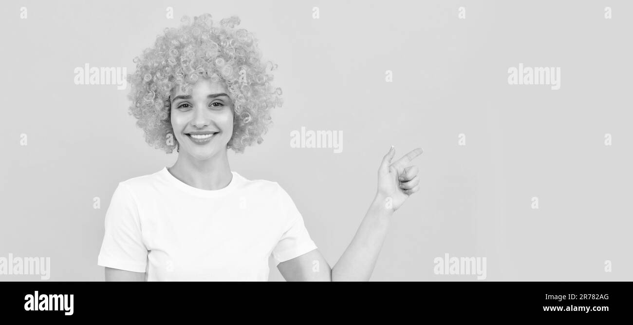 happy freaky woman in curly clown wig pointing finger, gesture and ...