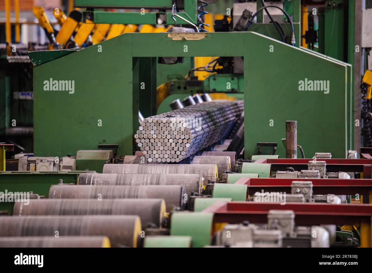Packs of rolled metal bars on roller conveyor Stock Photo - Alamy