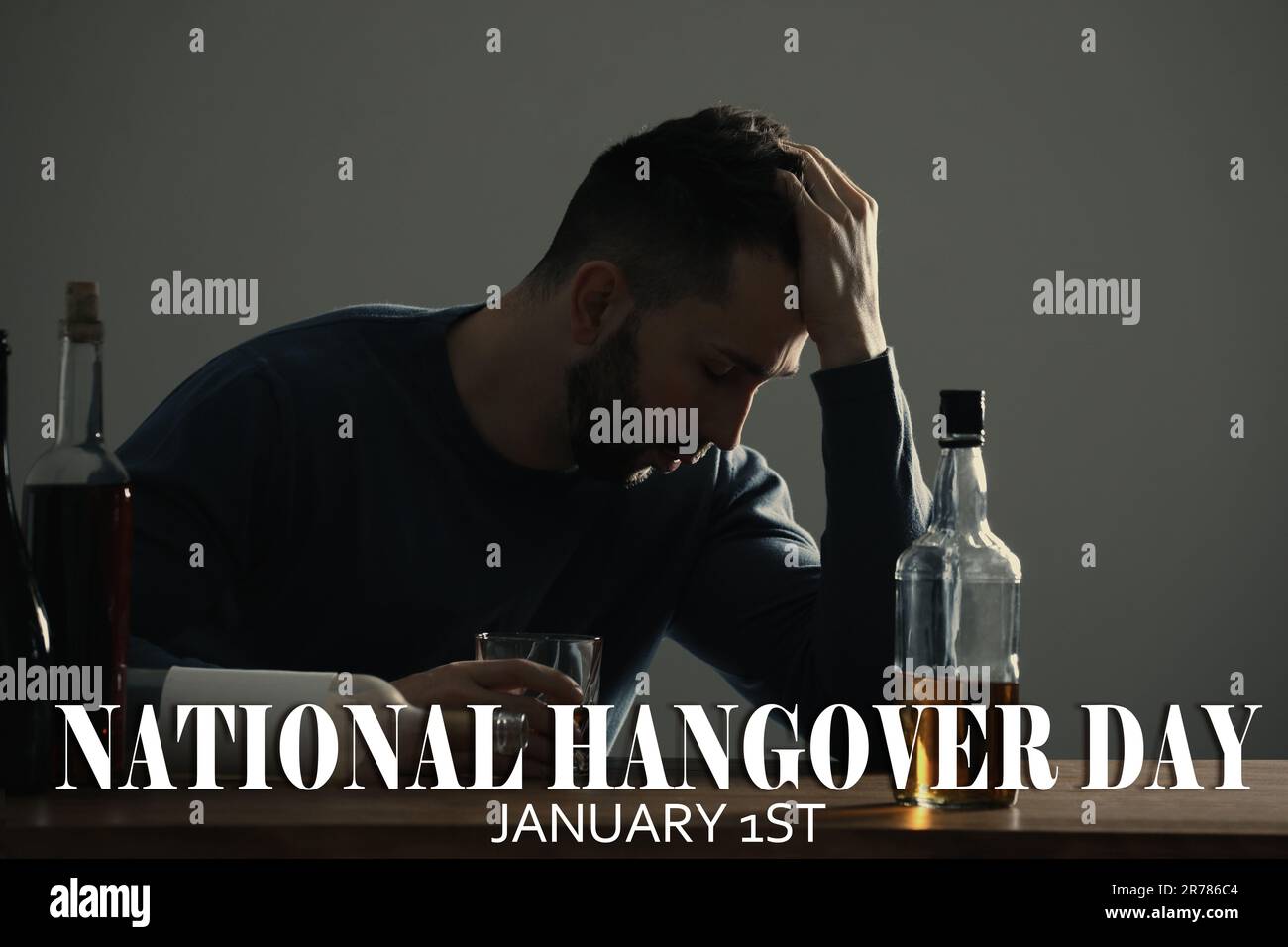 National hangover day - January 1st. Man with alcohol drink at table ...