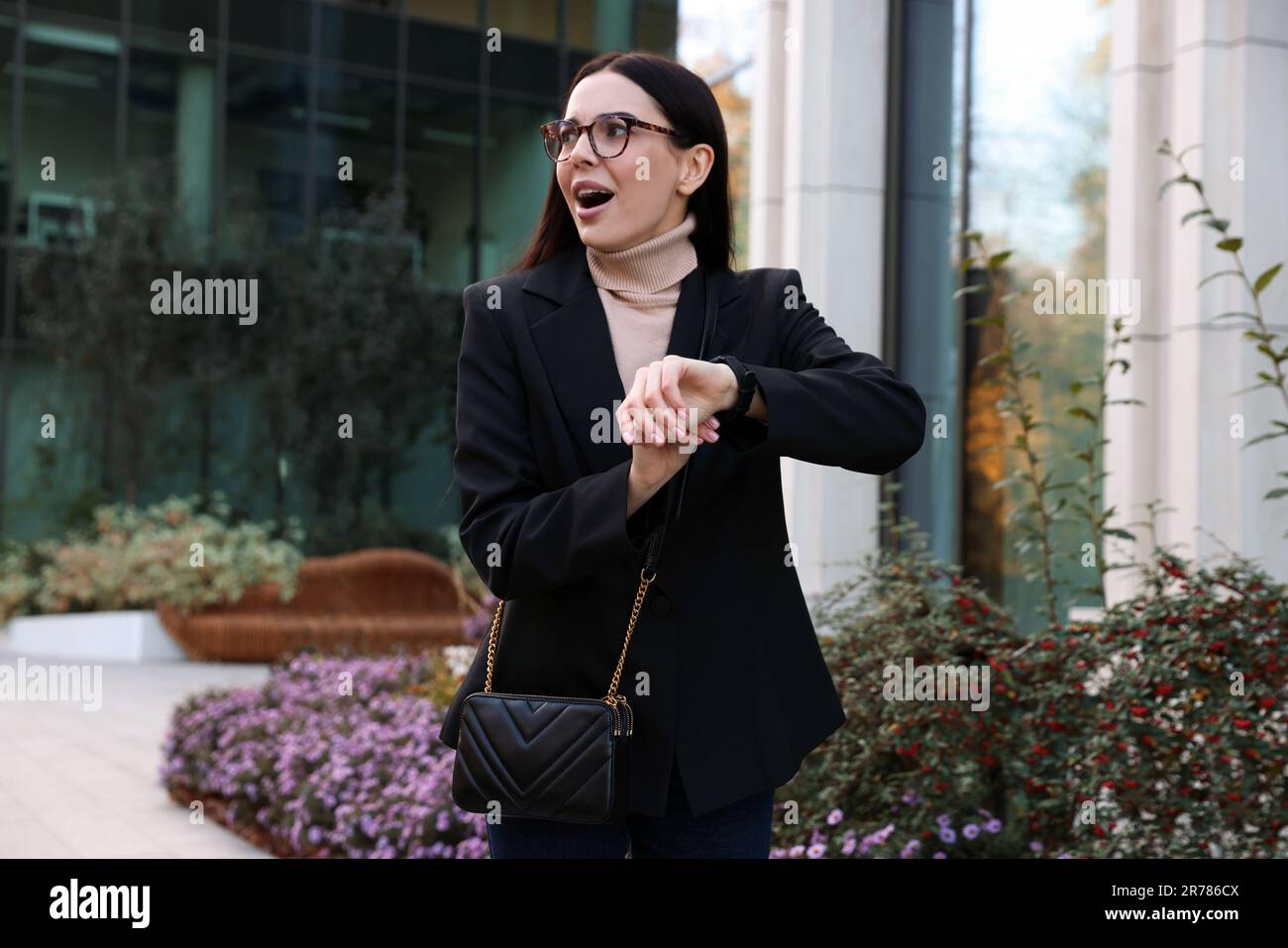 Emotional woman checking time on watch outdoors. Being late concept ...