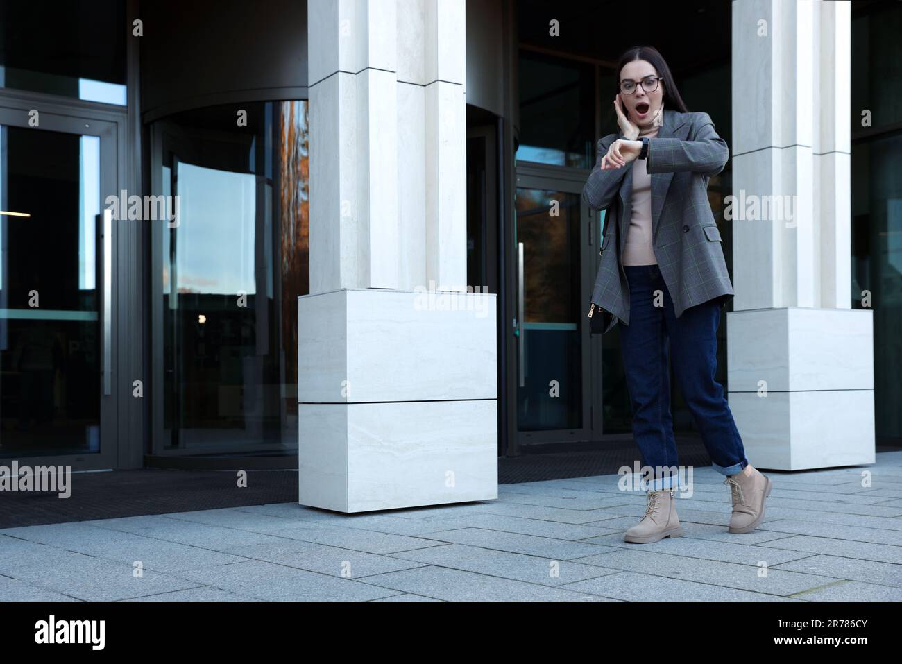 Emotional woman checking time on watch outdoors. Being late concept ...