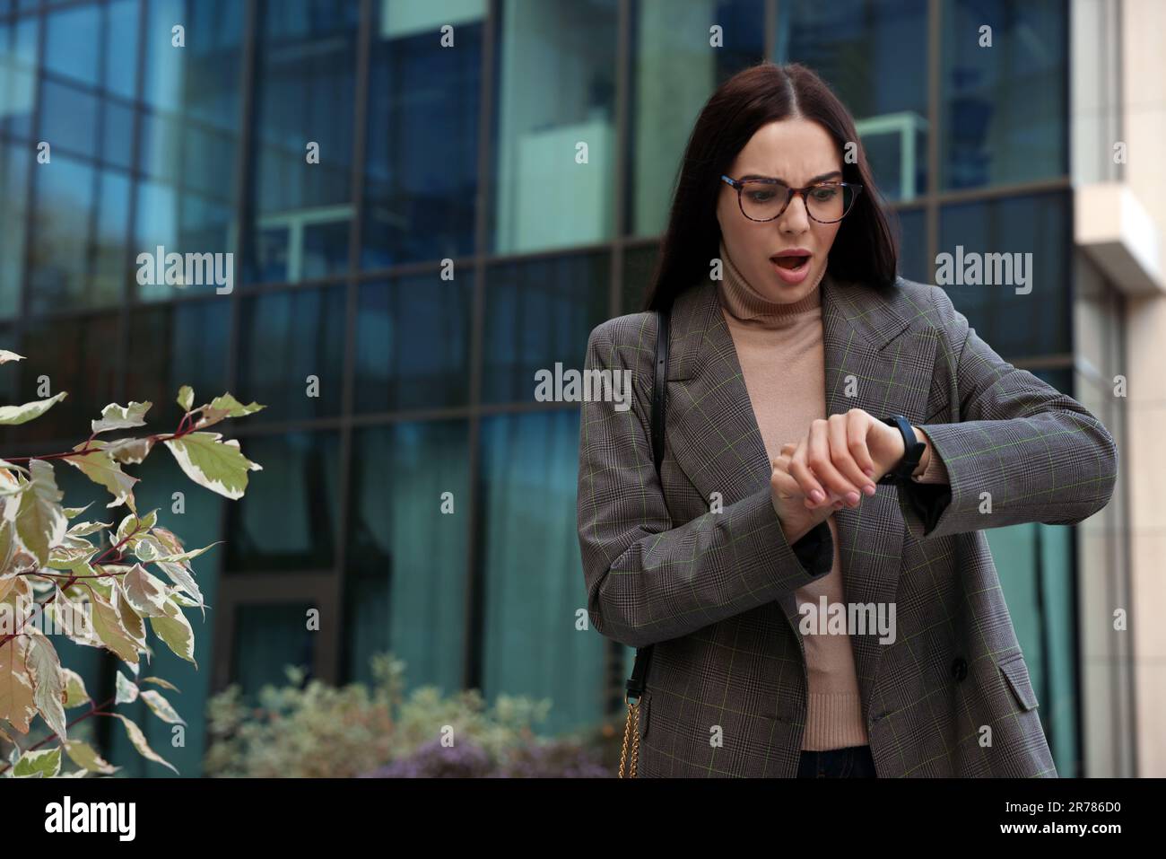 Emotional woman checking time on watch outdoors. Being late concept ...