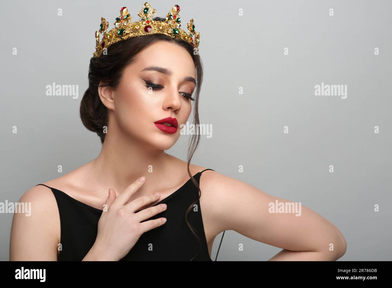 Beautiful young woman wearing luxurious crown on light grey background, space for text Stock ...