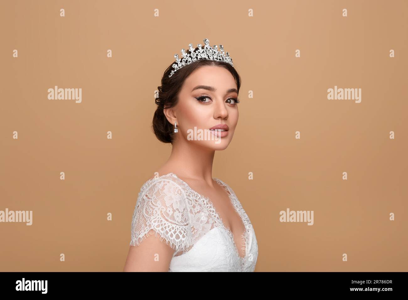 Beautiful young woman wearing luxurious tiara on beige background Stock Photo - Alamy