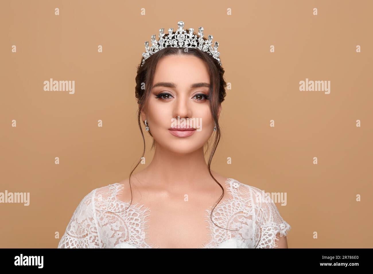 Beautiful young woman wearing luxurious tiara on beige background Stock Photo - Alamy