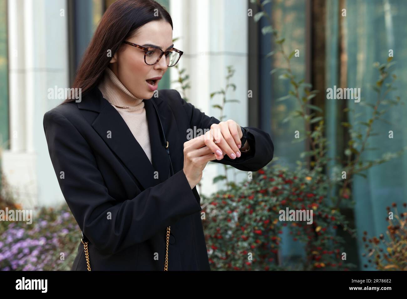 Emotional woman checking time on watch outdoors. Being late concept ...