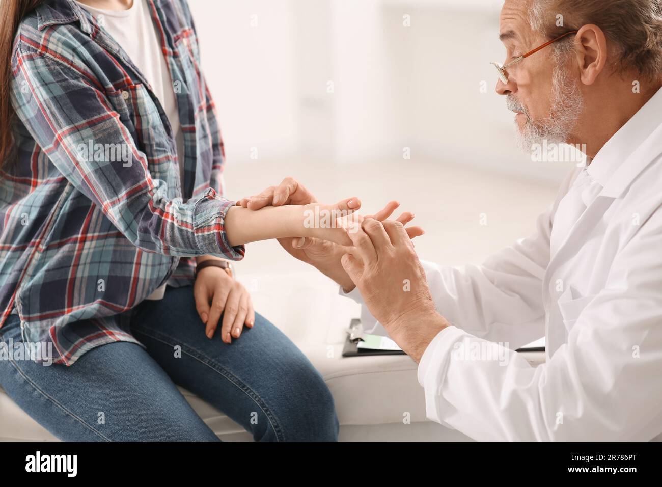 Orthopedist examining patient with injured hand in clinic, closeup ...