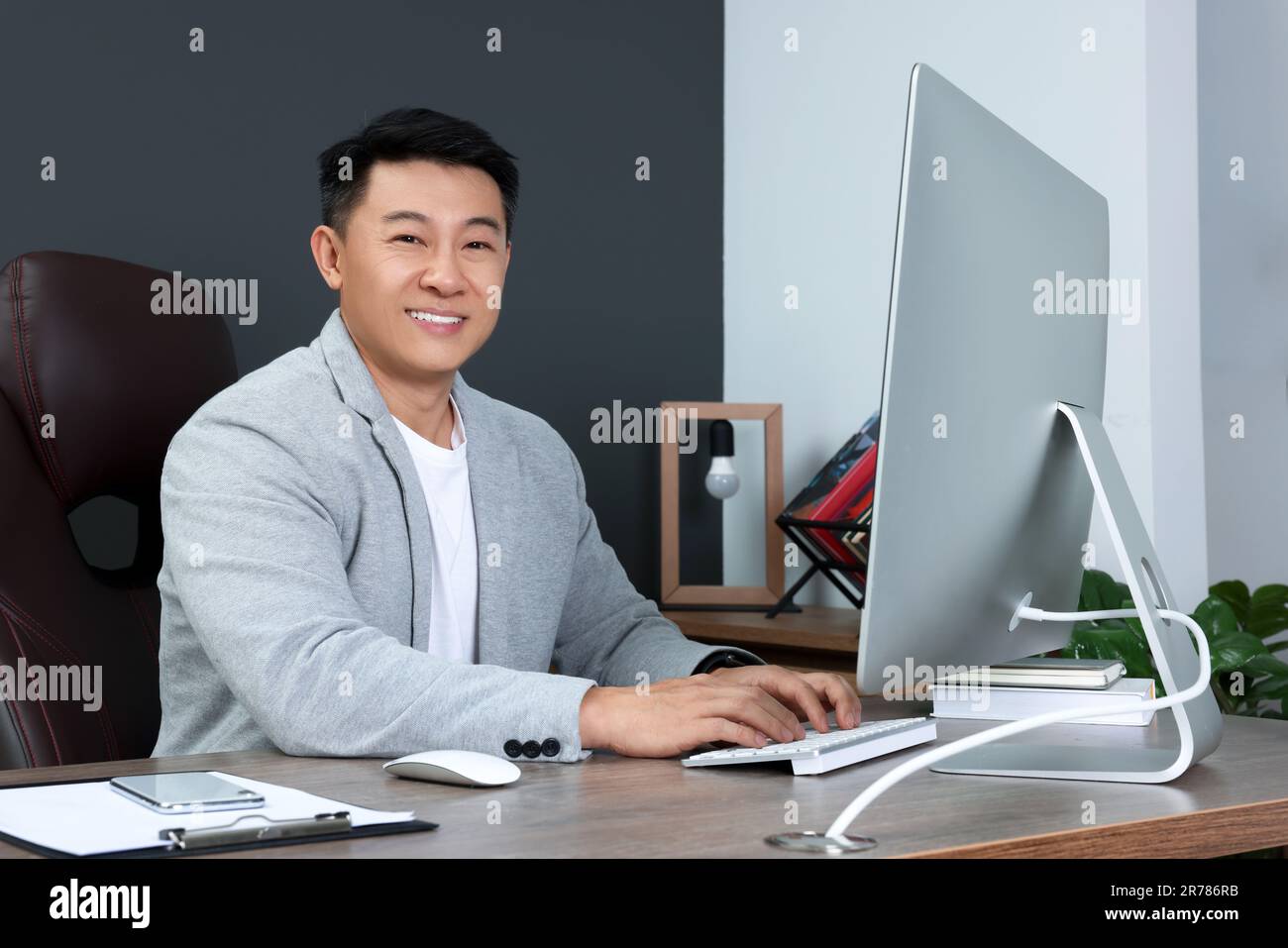 Happy successful boss working in his office Stock Photo - Alamy