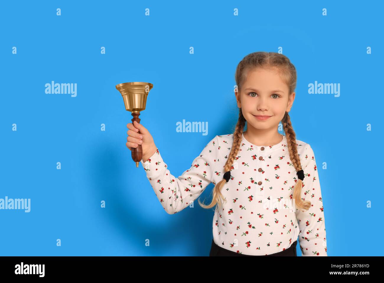 Pupil with school bell on light blue background Stock Photo - Alamy