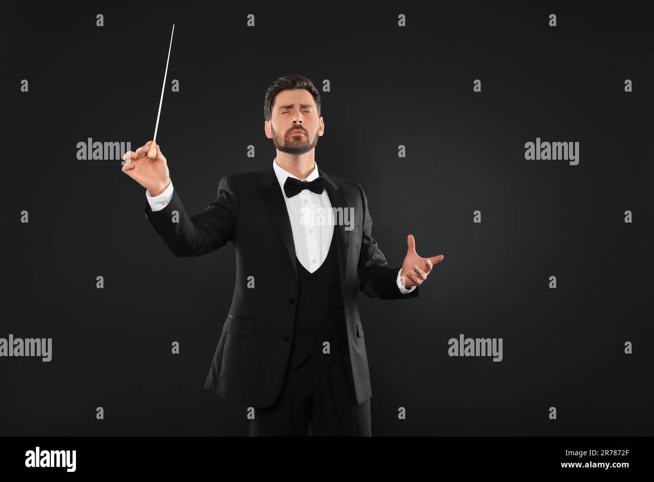 Professional conductor with baton on black background Stock Photo - Alamy