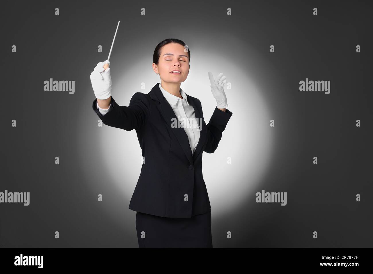 Professional conductor with baton on grey background Stock Photo - Alamy