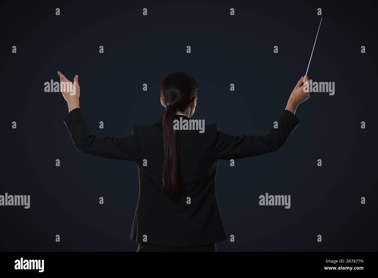 Professional conductor with baton on dark background, back view Stock ...