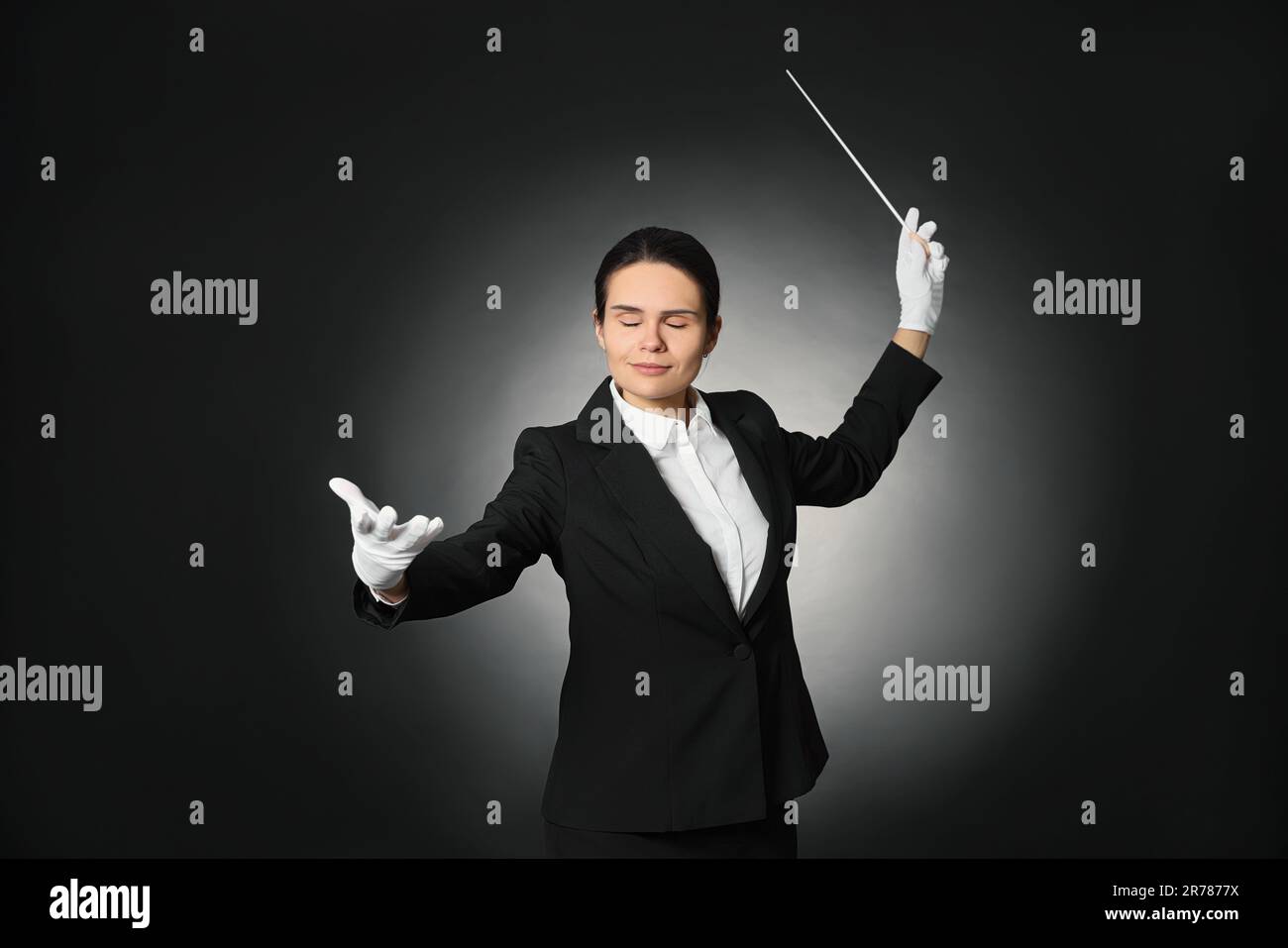 Professional conductor with baton on black background Stock Photo - Alamy