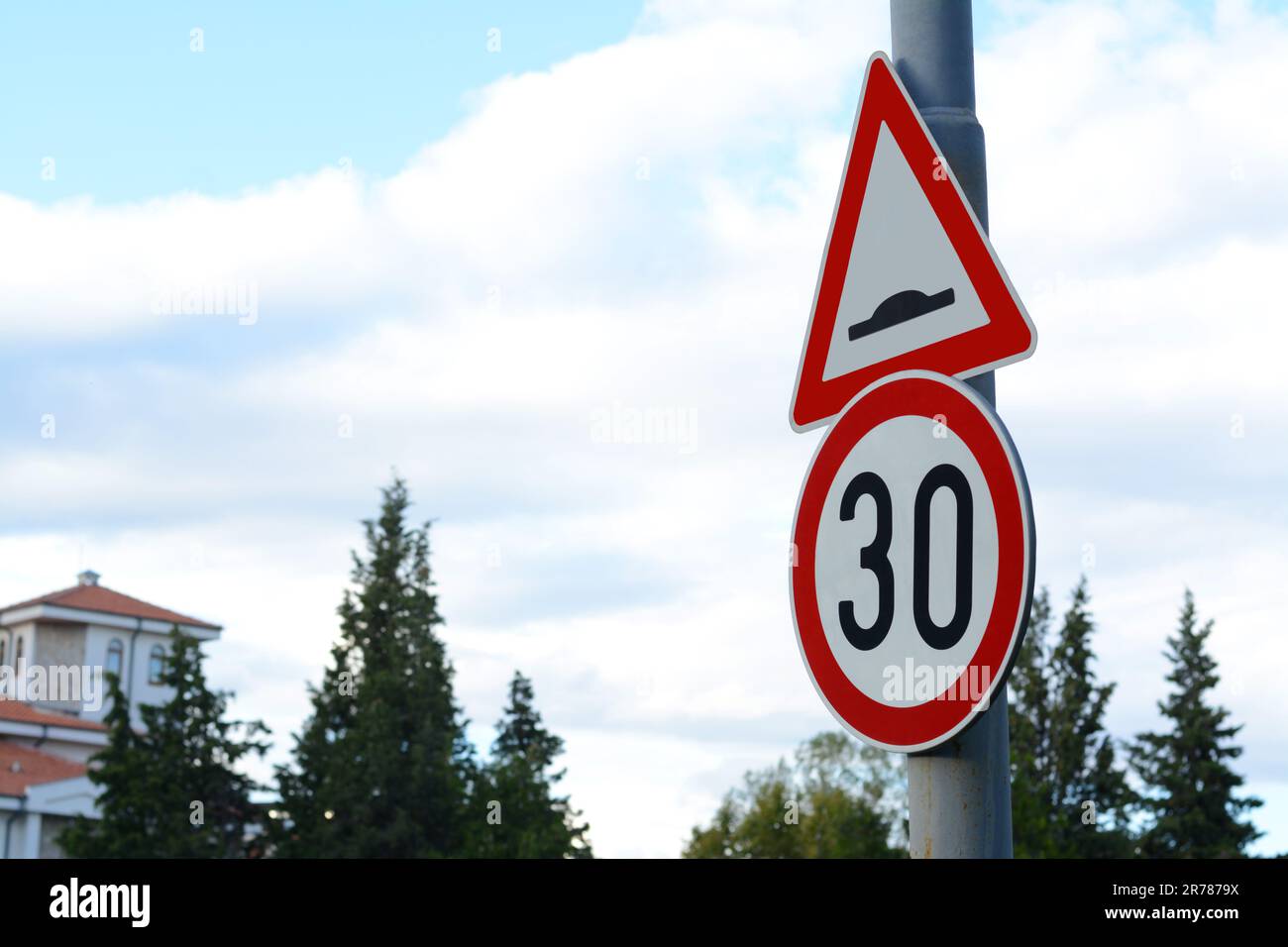 Post with road signs Maximum Speed 30 and Speed Bump outdoors on sunny ...