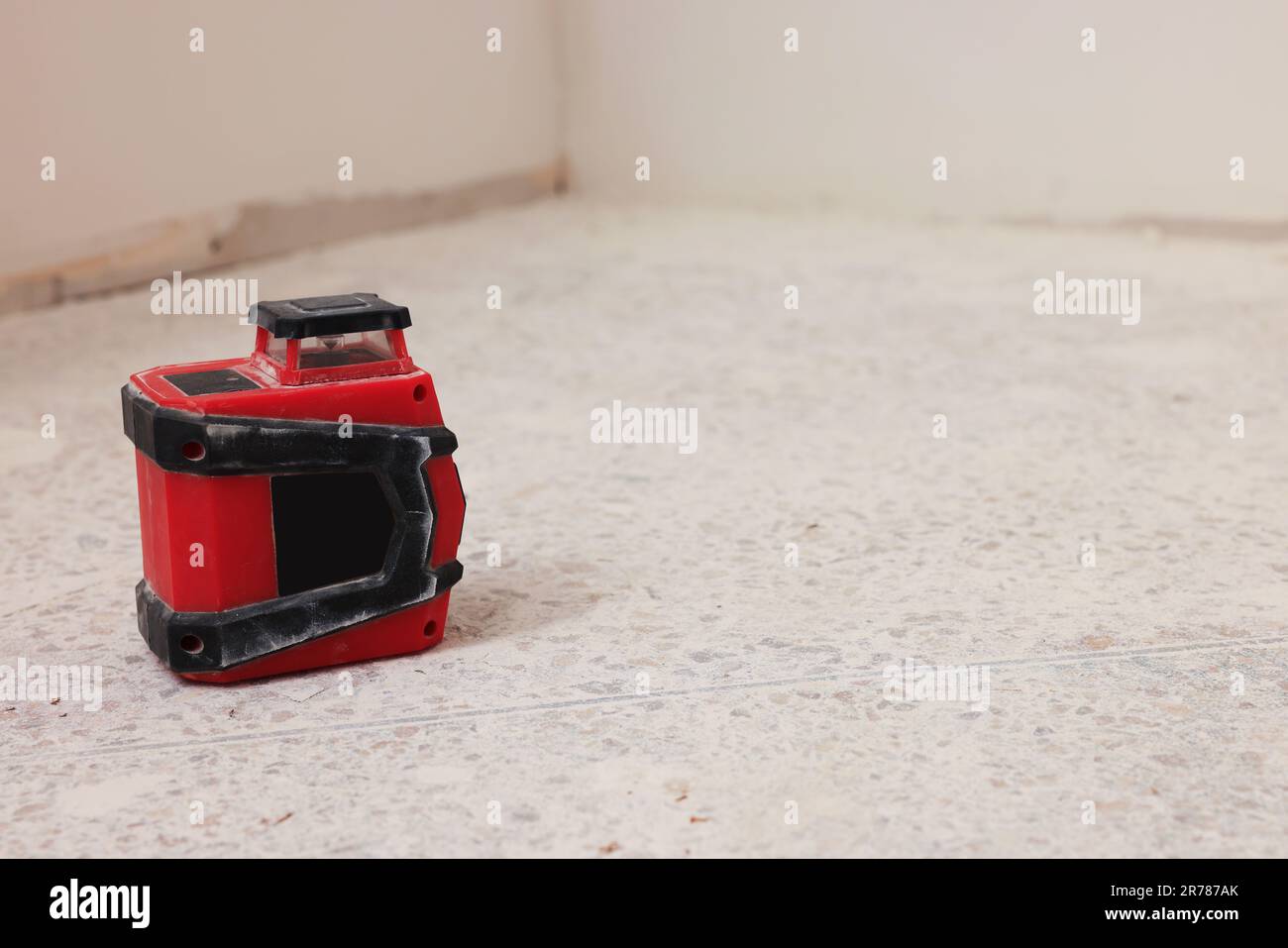 Cross line laser level on floor indoors, space for text. Tiles ...